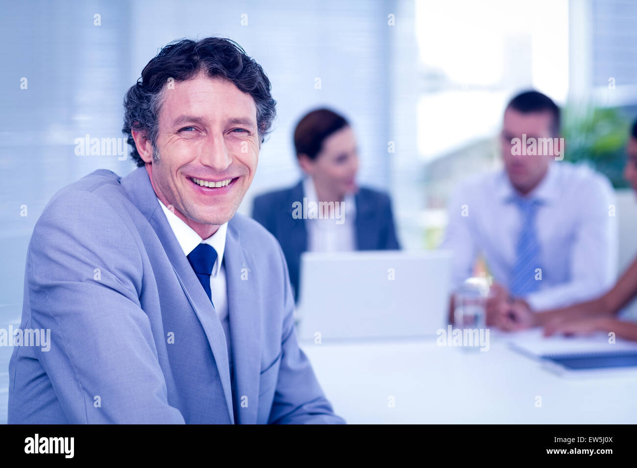 Businessman smiling in a meeting Stock Photo - Alamy