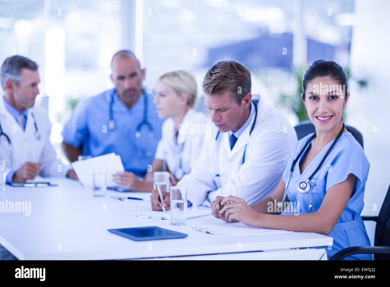 Nurse smiling at camera during meeting Stock Photo - Alamy