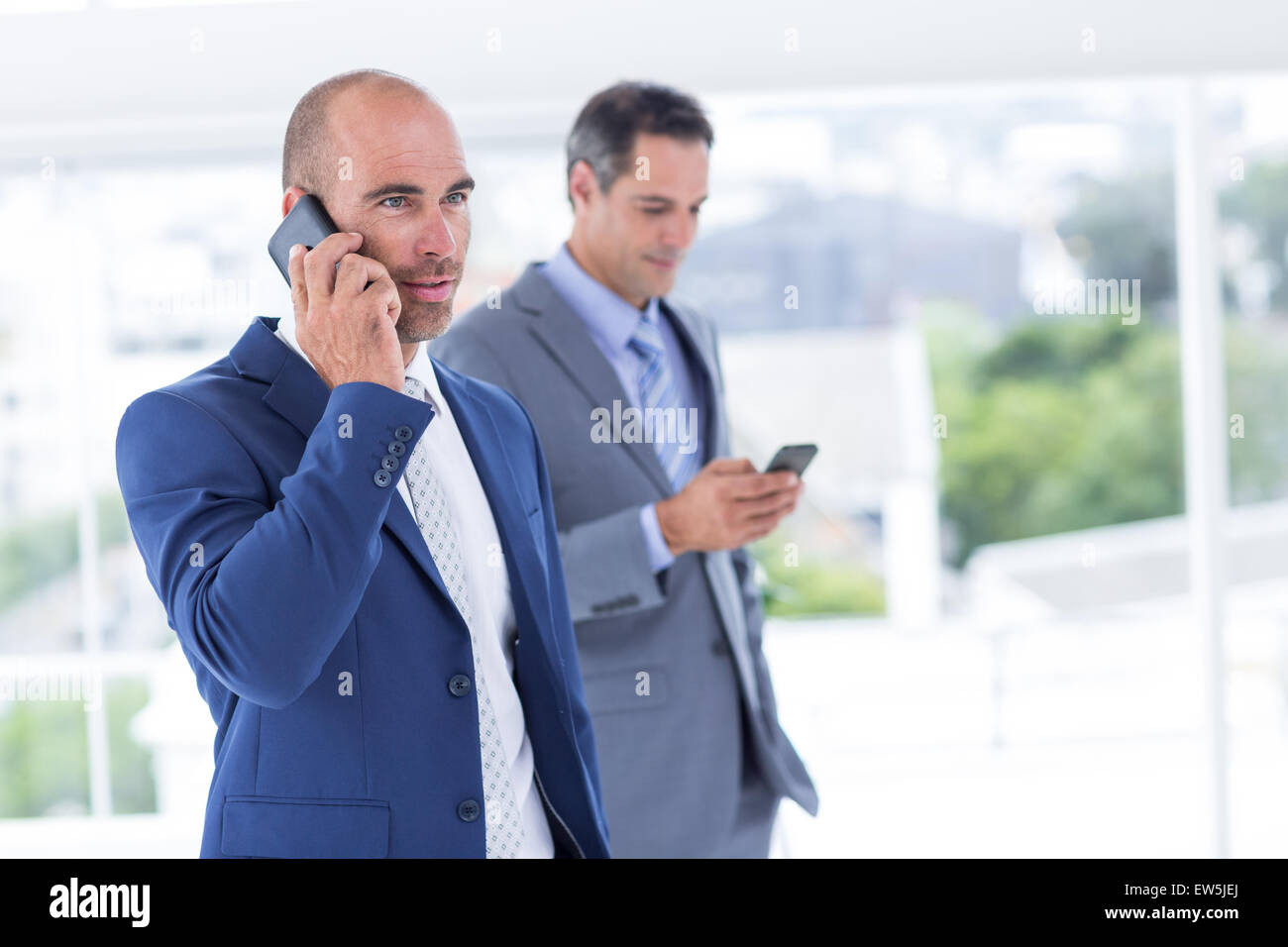 Business colleagues using phones Stock Photo - Alamy