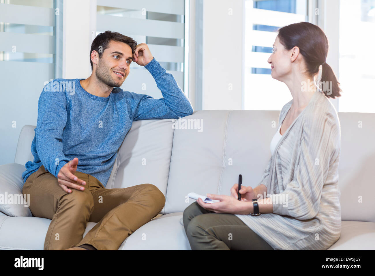 Psychologist talking with happy man Stock Photo - Alamy