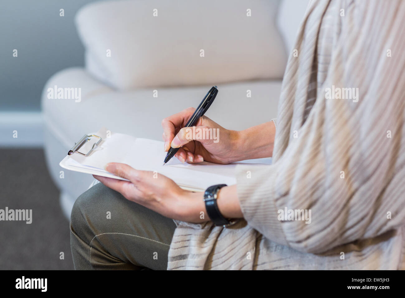 Psychologist sitting on the couch and taking notes Stock Photo - Alamy