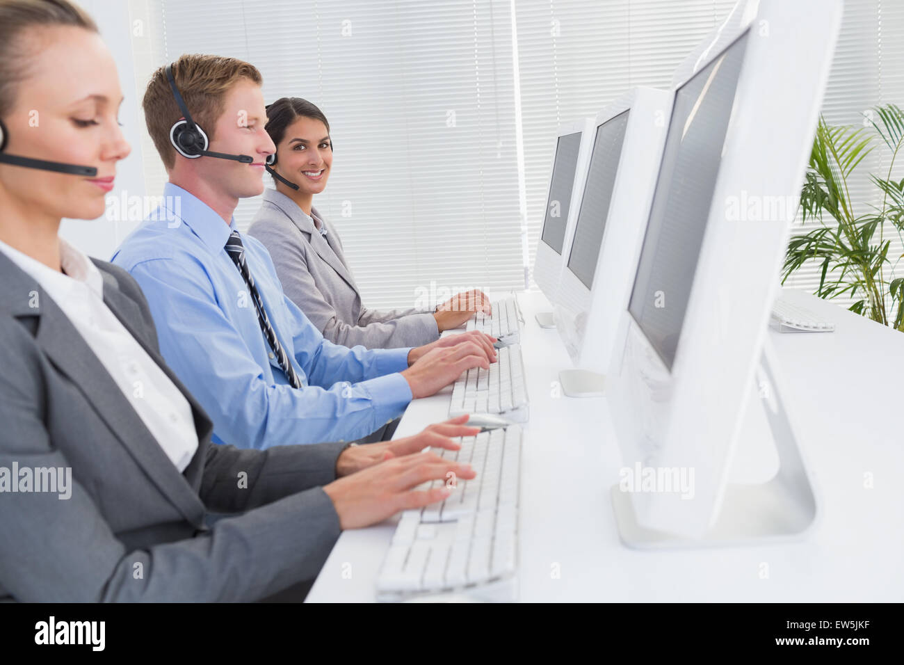 Business team working on computers and wearing headsets Stock Photo - Alamy