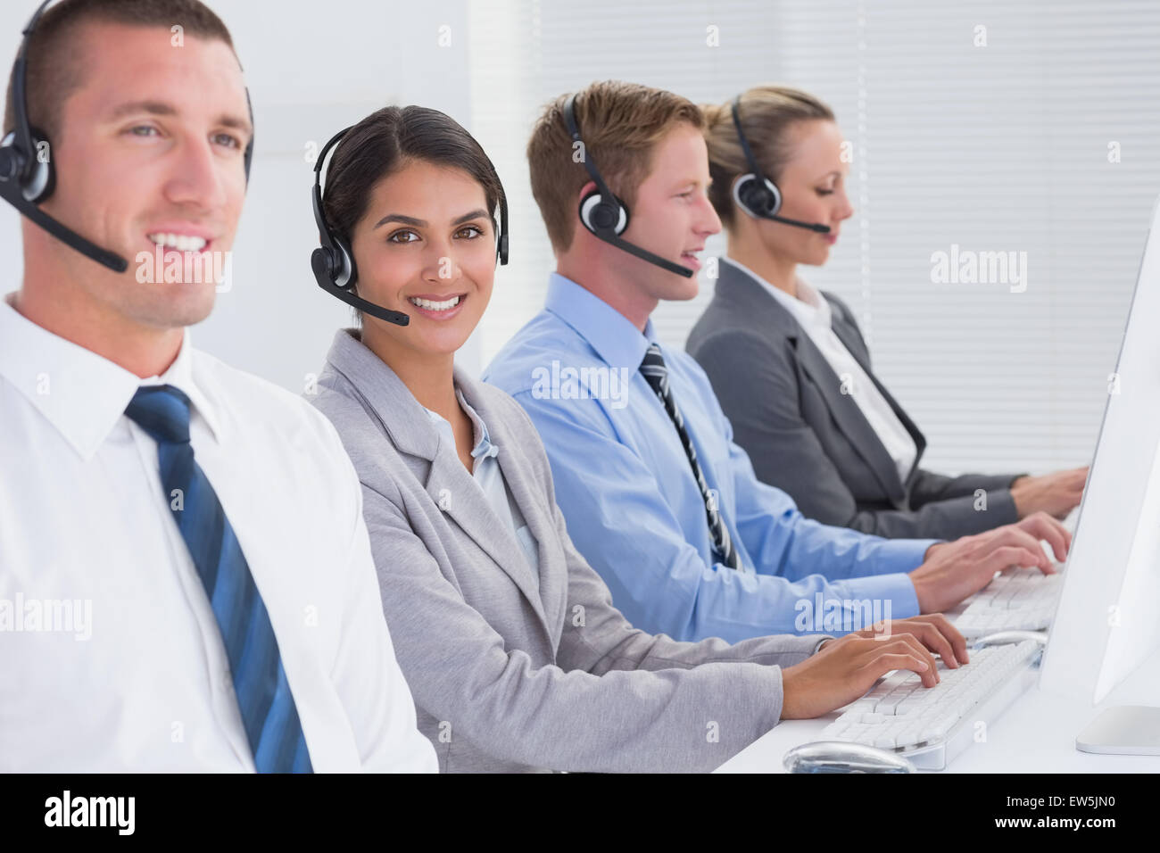 Business team working on computers and wearing headsets Stock Photo - Alamy