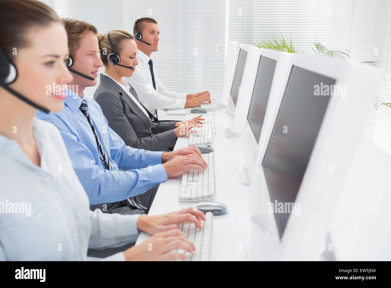 Business team working on computers and wearing headsets Stock Photo - Alamy