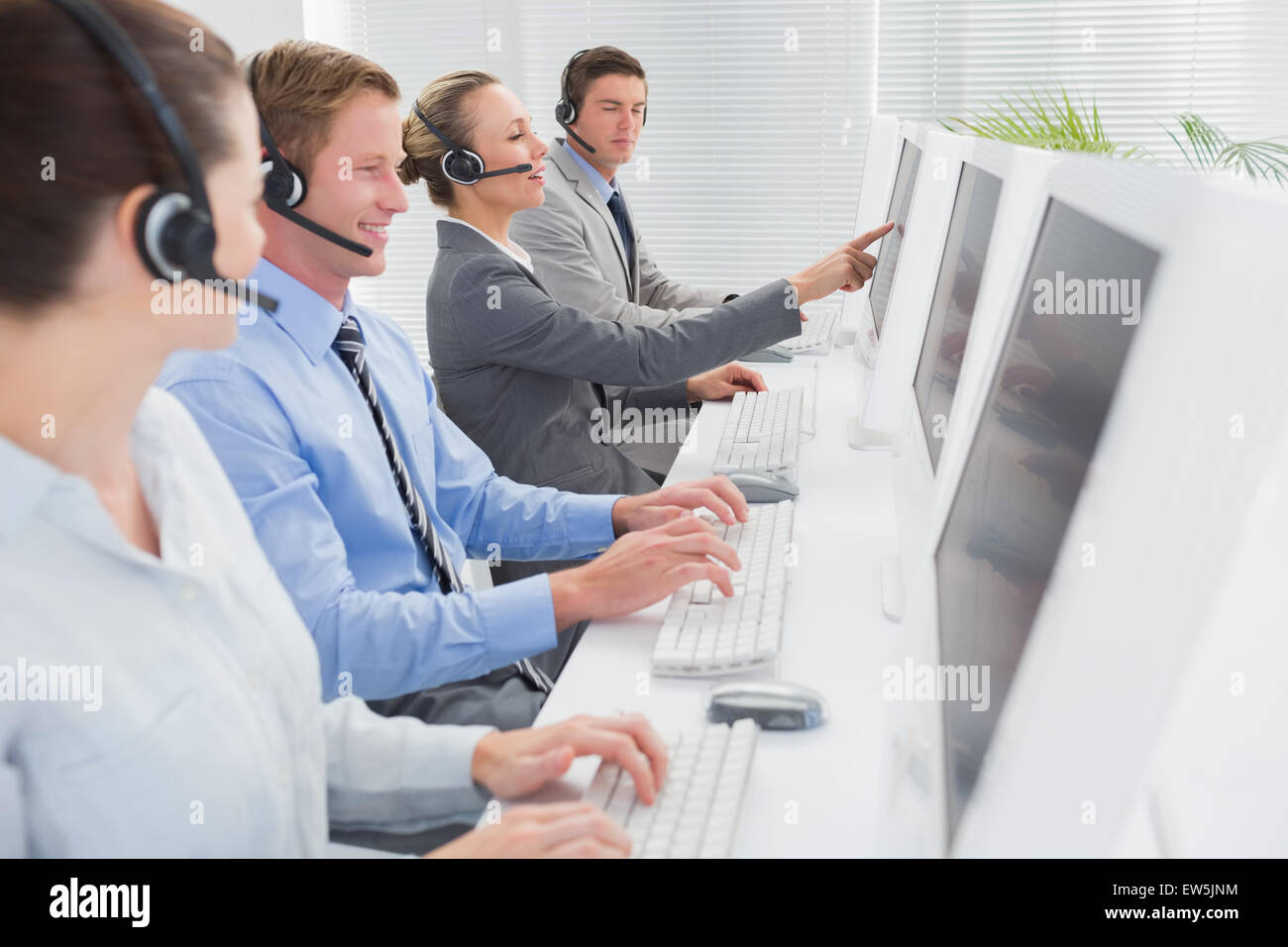 Business team working on computers and wearing headsets Stock Photo - Alamy