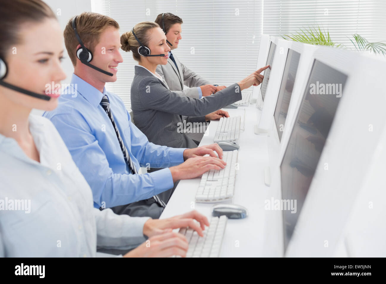 Business team working on computers and wearing headsets Stock Photo - Alamy