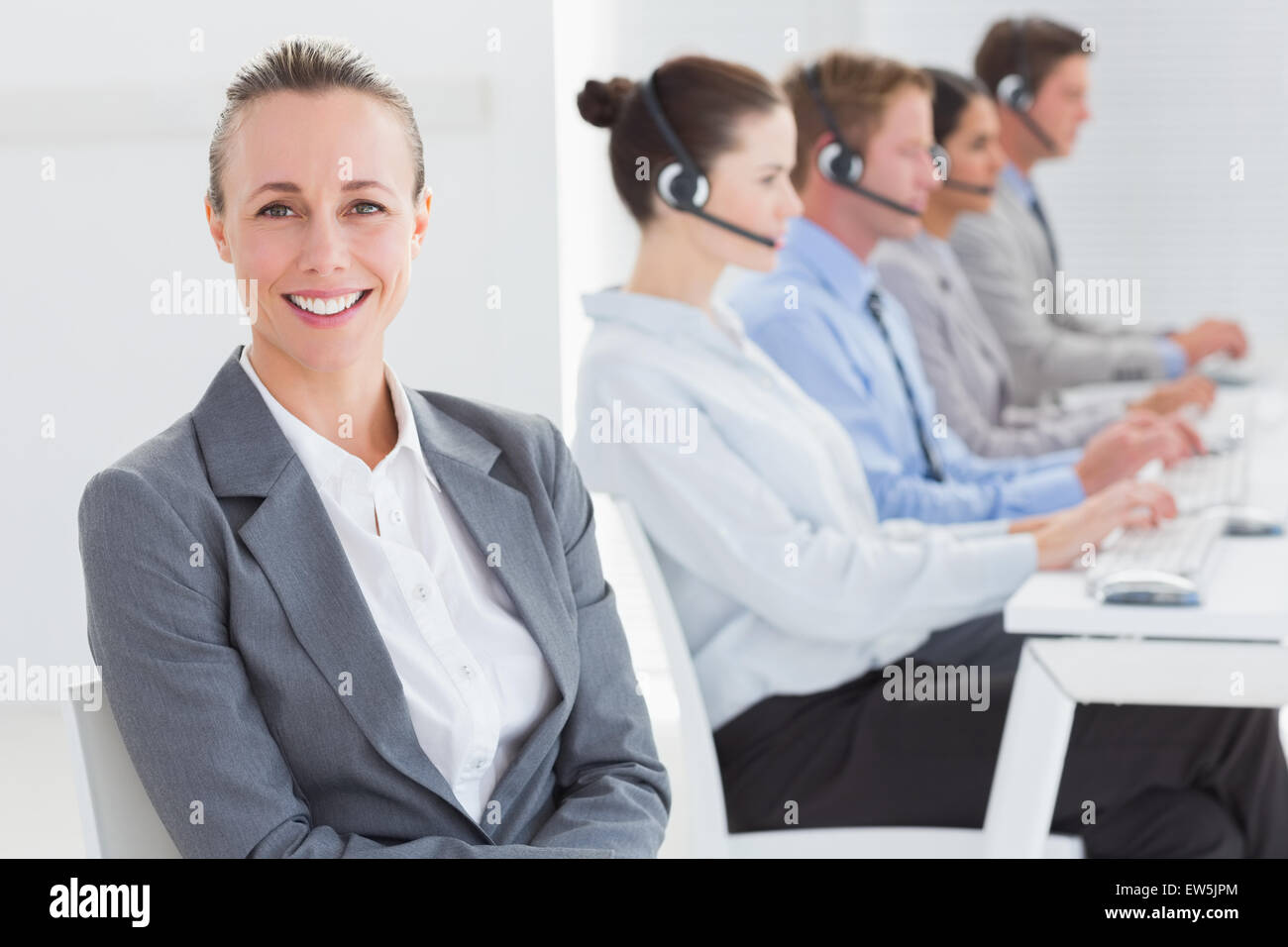 Manager smiling at camera with her staff behind Stock Photo - Alamy