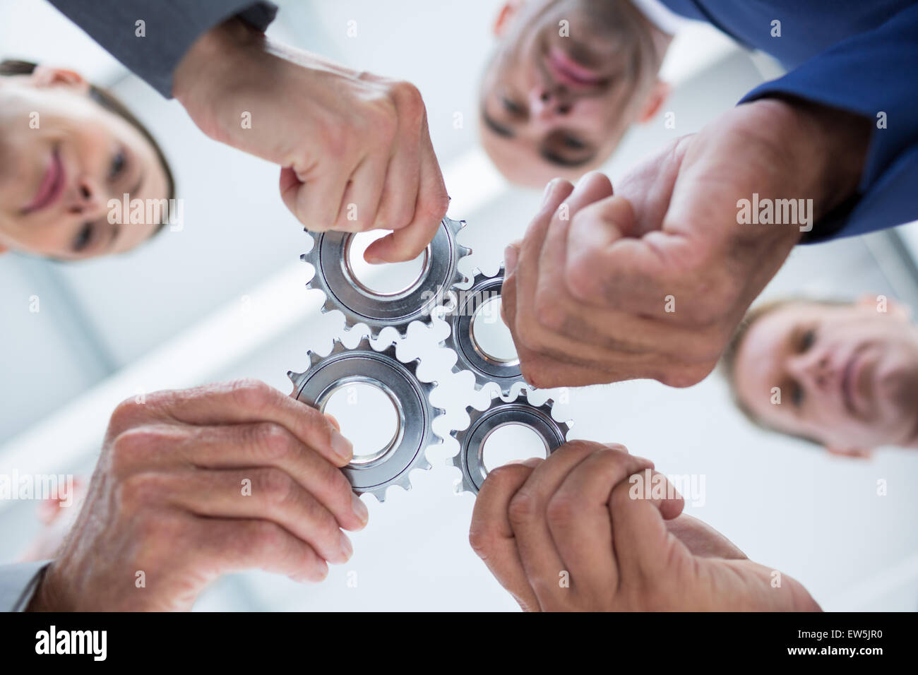Business colleagues holding cog Stock Photo - Alamy