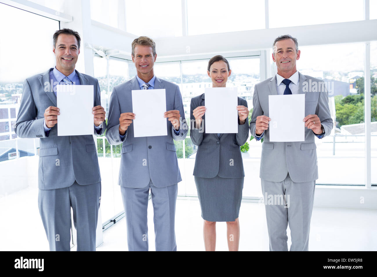 Business colleagues holding sheets of paper together Stock Photo - Alamy