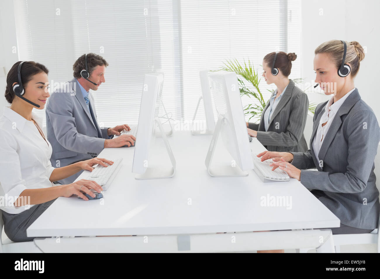 Business team working on computers and wearing headsets Stock Photo - Alamy
