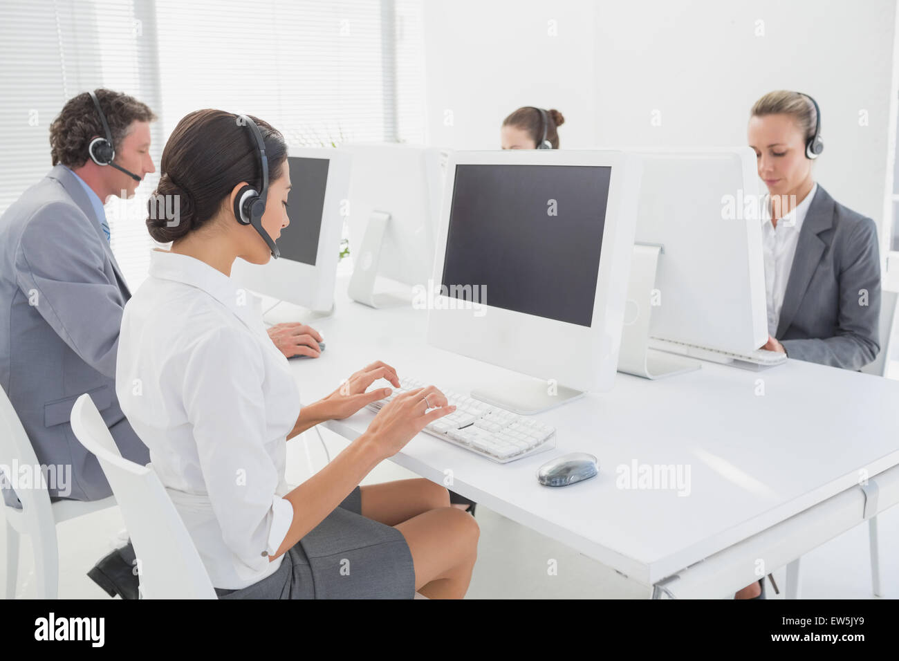 Business team working on computers and wearing headsets Stock Photo - Alamy