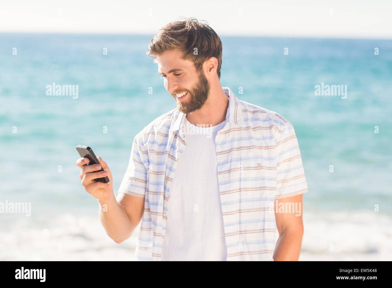 Happy man playing on his smartphone Stock Photo - Alamy