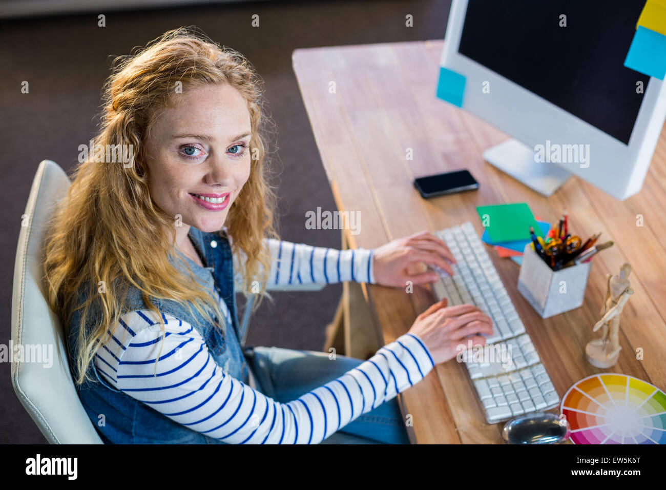 Smiling designer typing on keyboard Stock Photo - Alamy