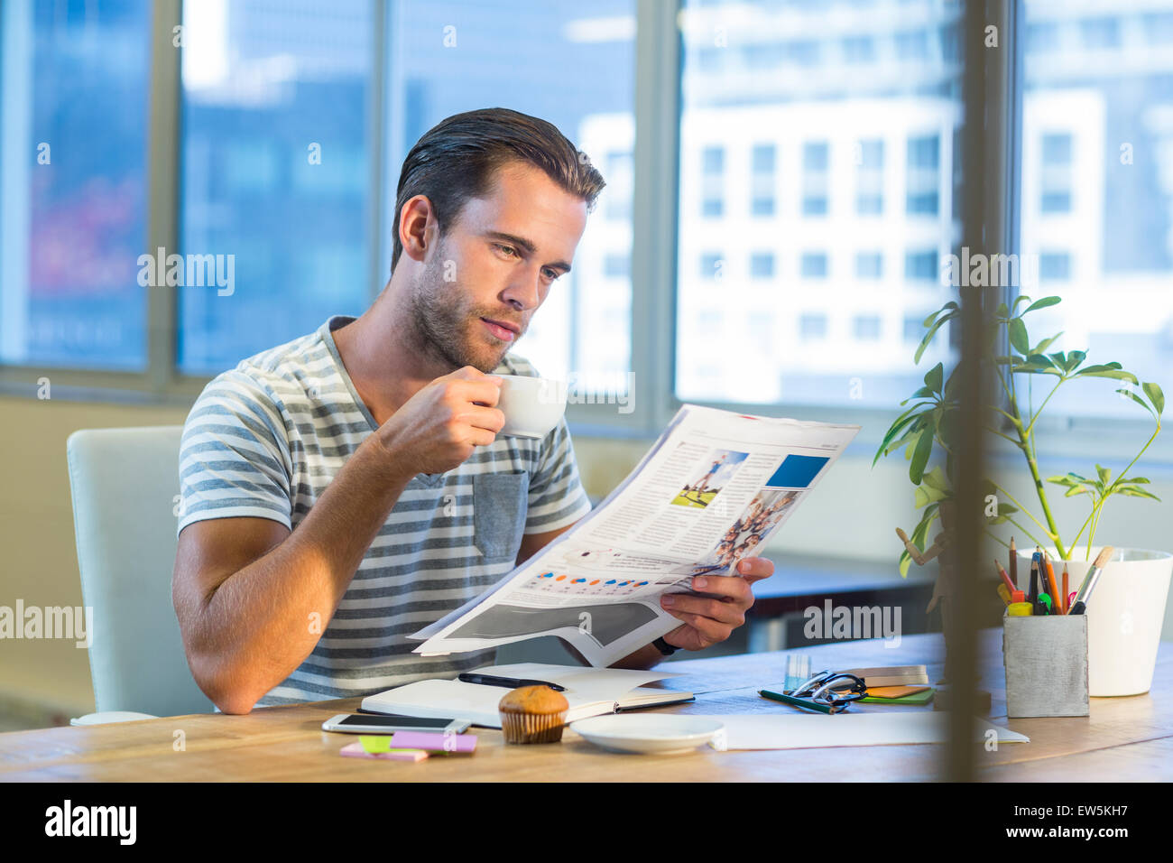 Young businessman reading magazine desk hi-res stock photography and ...