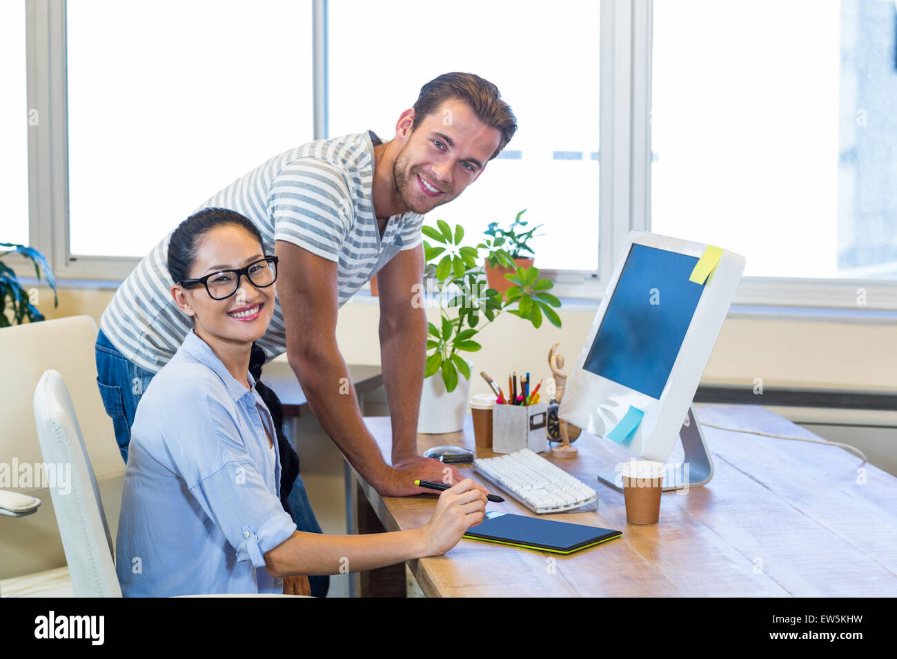 Smiling partners working together on computer Stock Photo - Alamy
