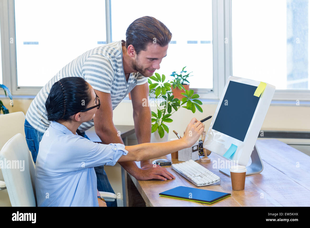 Smiling partners working together on computer Stock Photo - Alamy