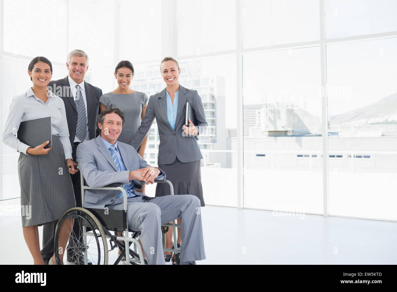 Disabled businessman with his colleagues smiling at camera Stock Photo ...