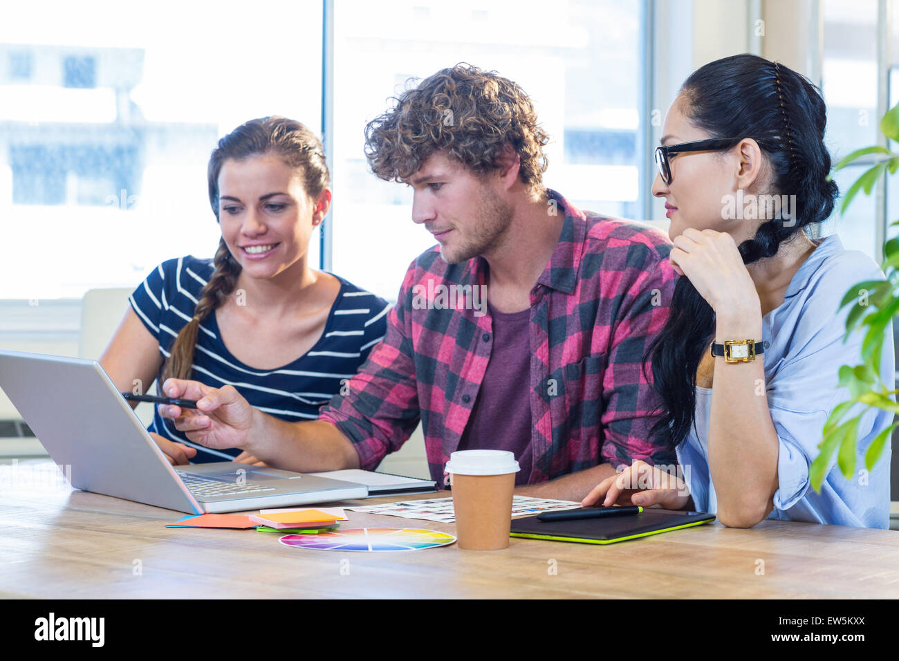 Smiling partners working together with photographs Stock Photo - Alamy