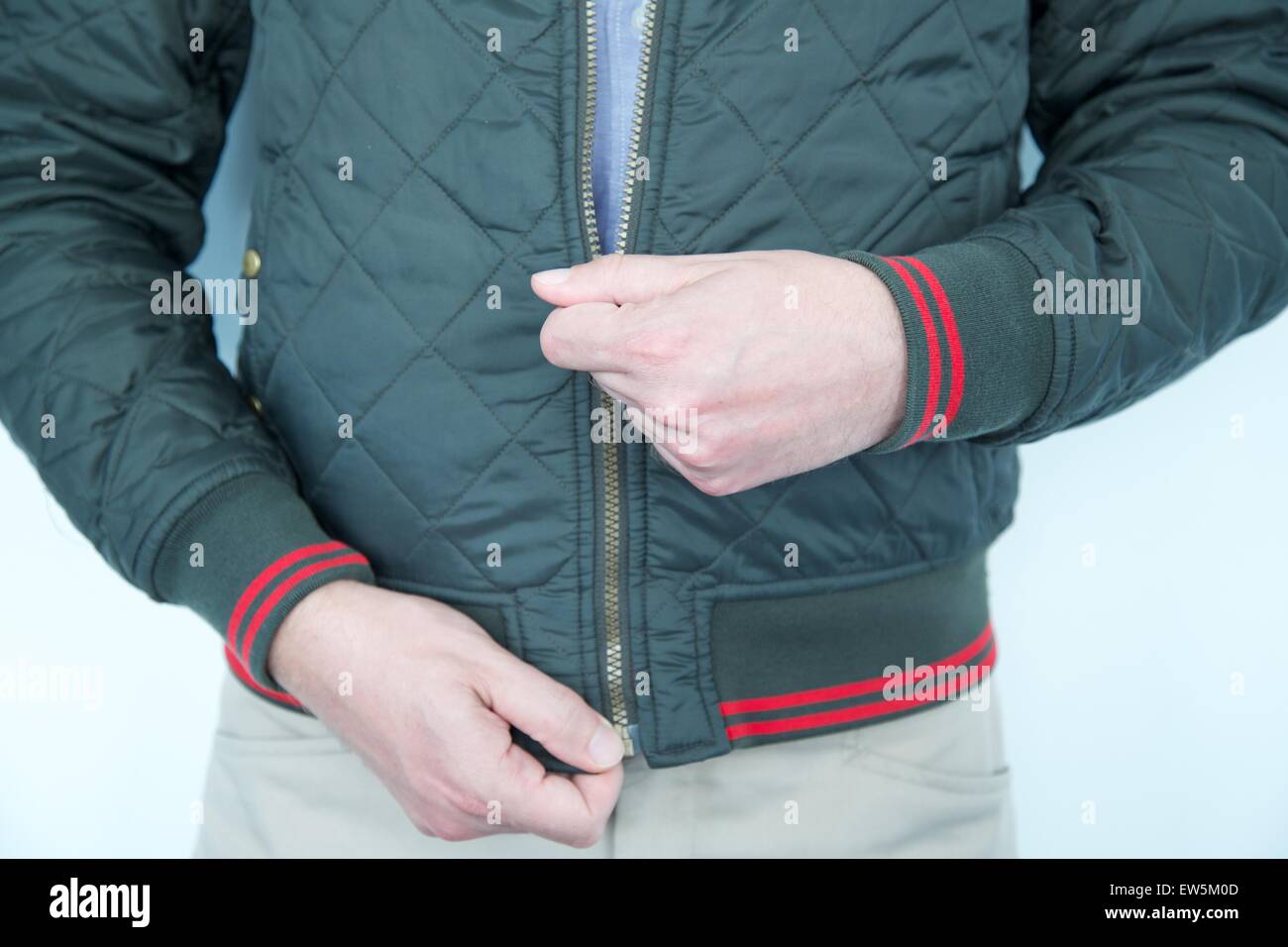 Young, white caucasian male zipping up his jacket Stock Photo - Alamy