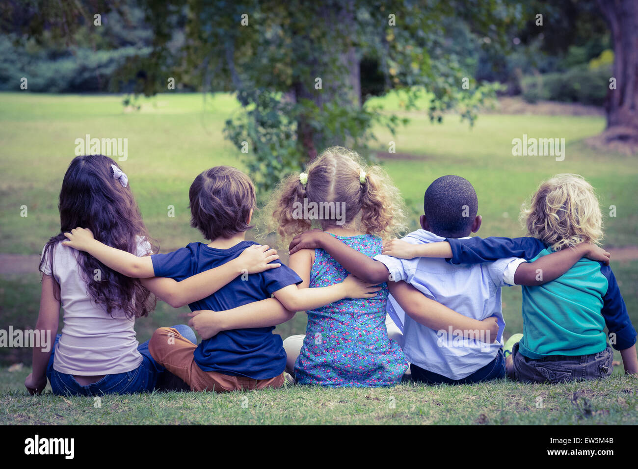 Back turned sitting children in the park Stock Photo - Alamy