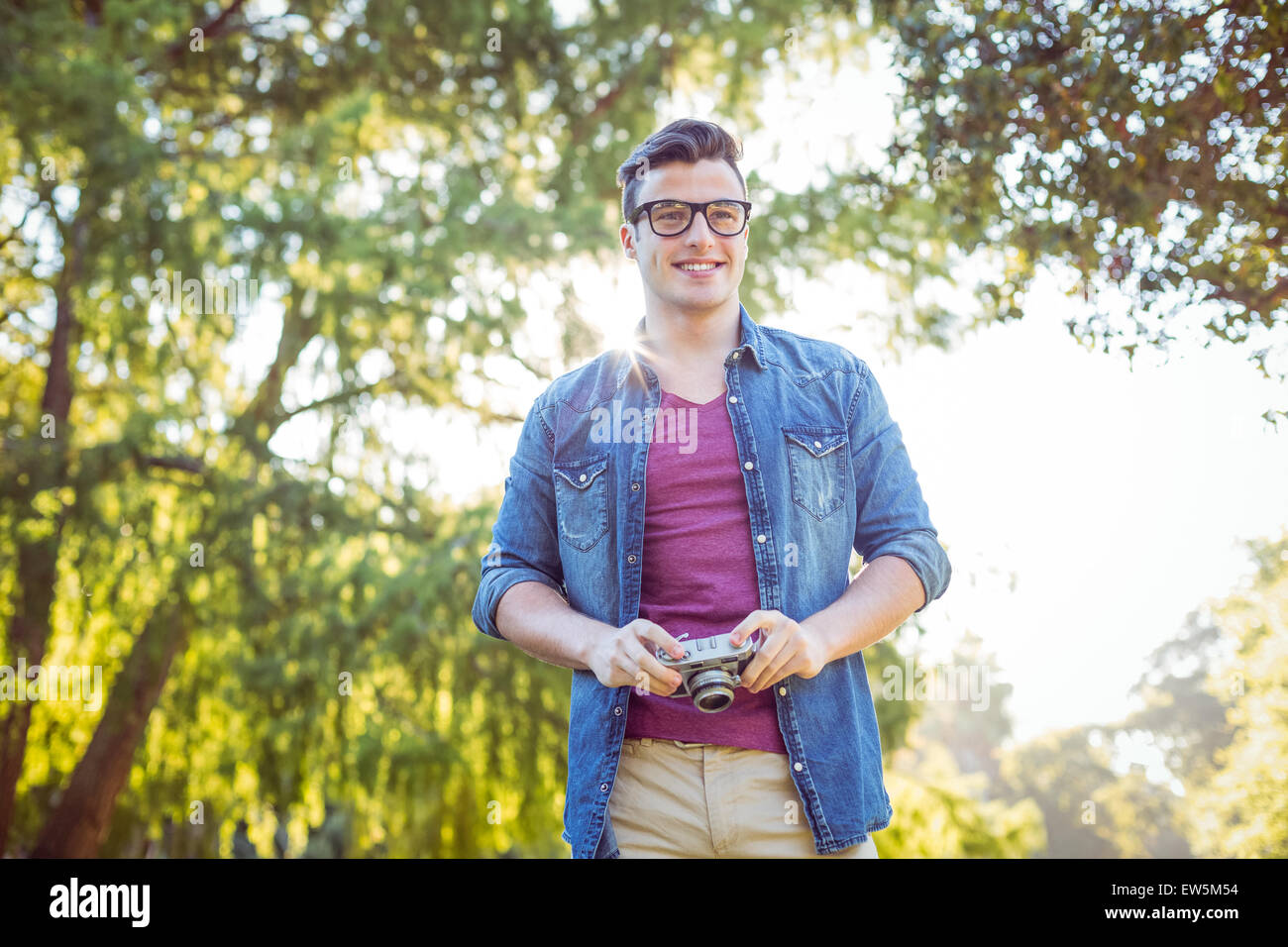 Handsome hipster holding vintage camera Stock Photo - Alamy
