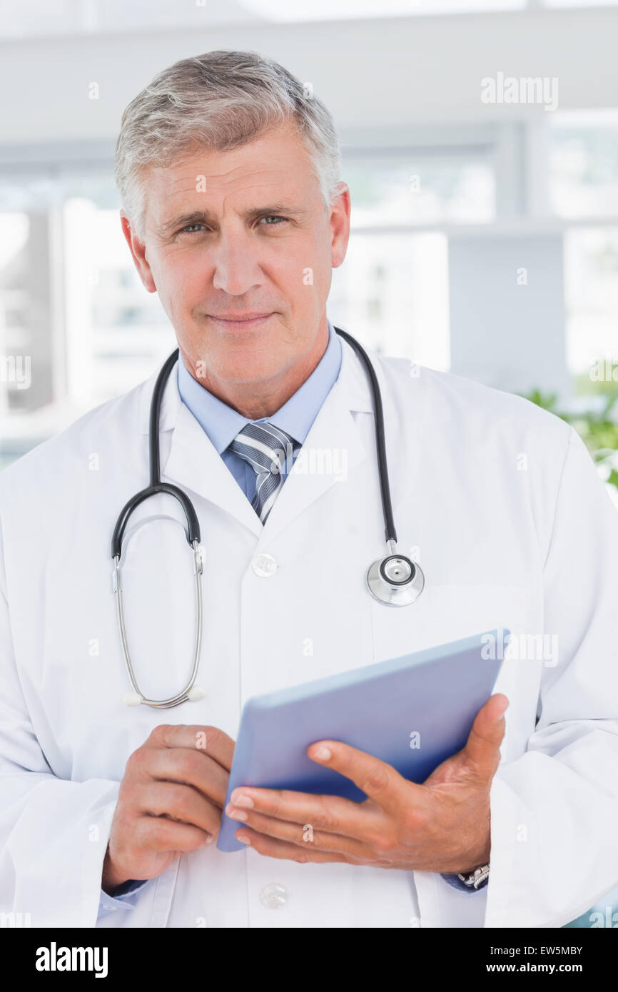 Smiling doctor holding tablet Stock Photo - Alamy