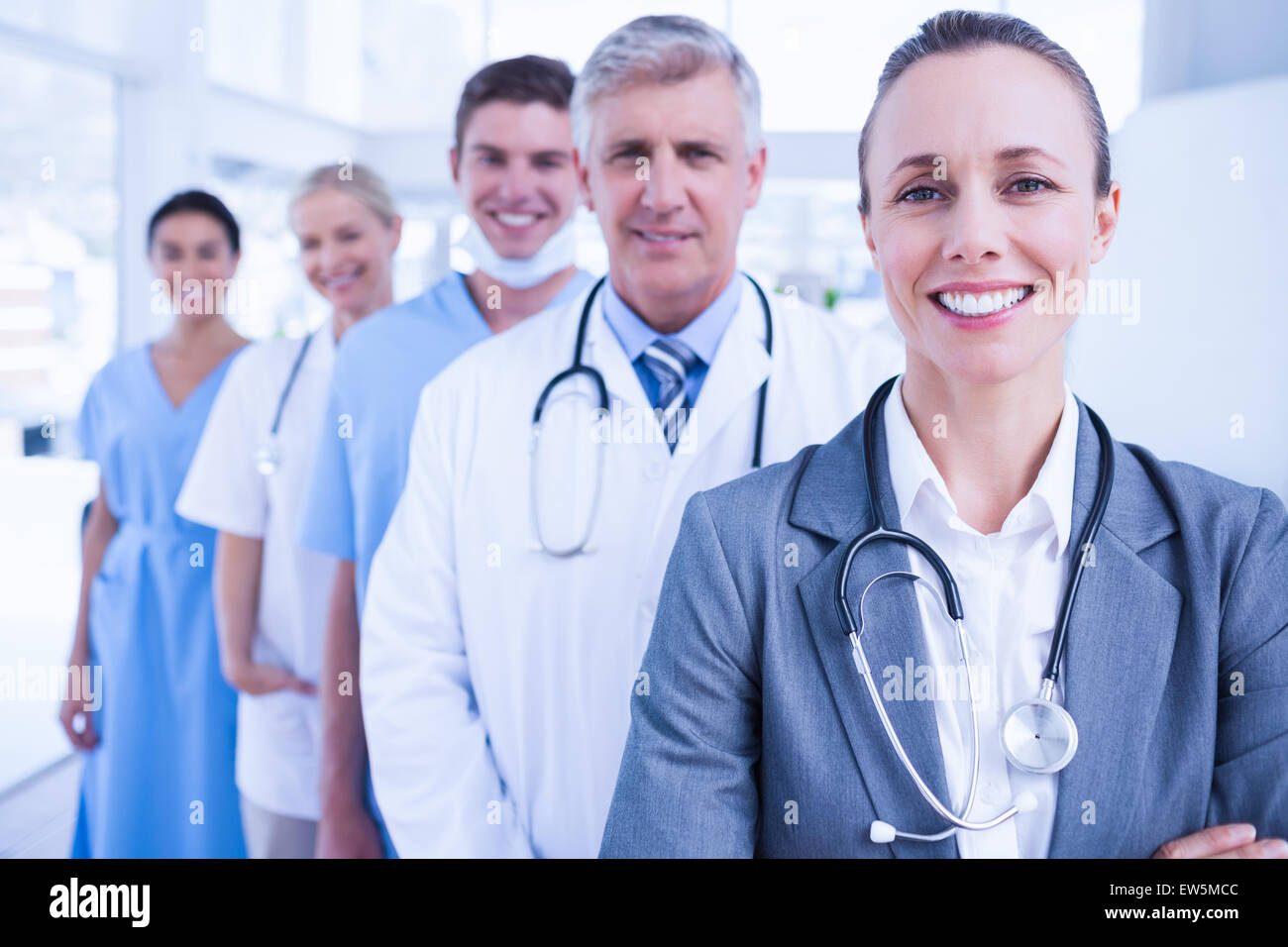 Smiling team of doctors standing in line Stock Photo - Alamy