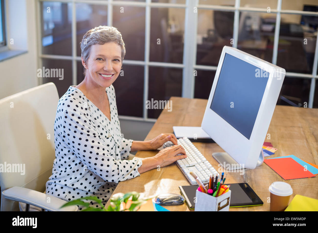 Smiling businesswoman typing on keyboard Stock Photo - Alamy