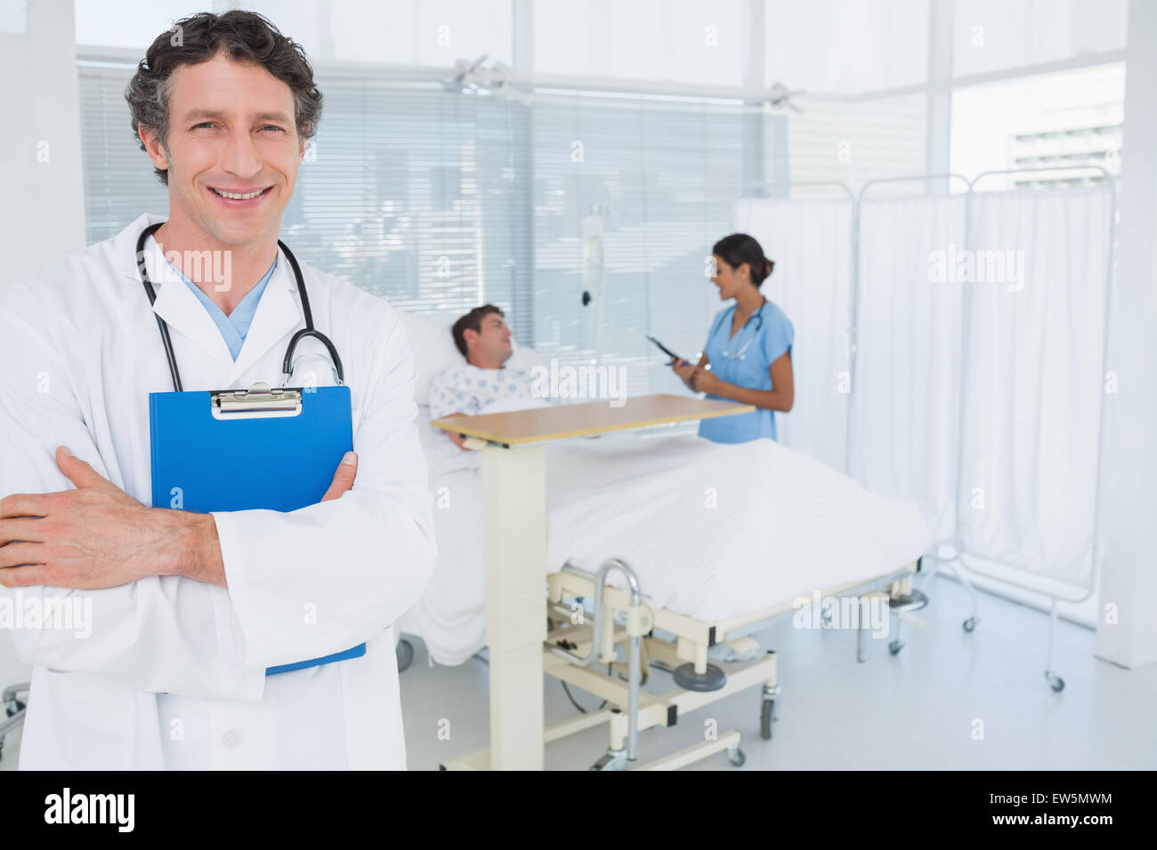 Smiling doctor holding patients file Stock Photo - Alamy
