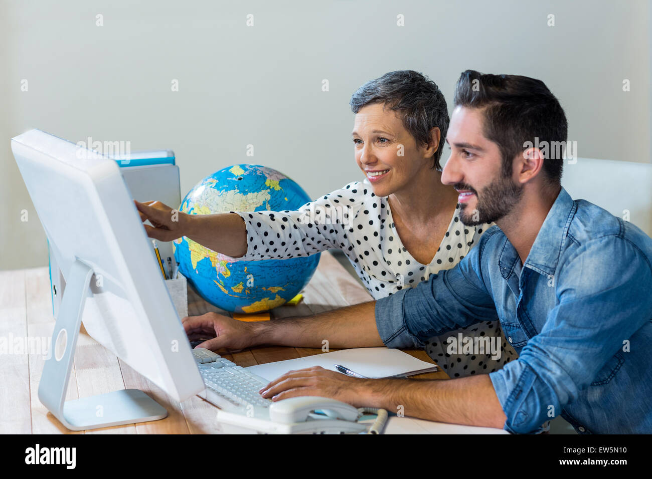 Smiling business people working together on computer Stock Photo - Alamy