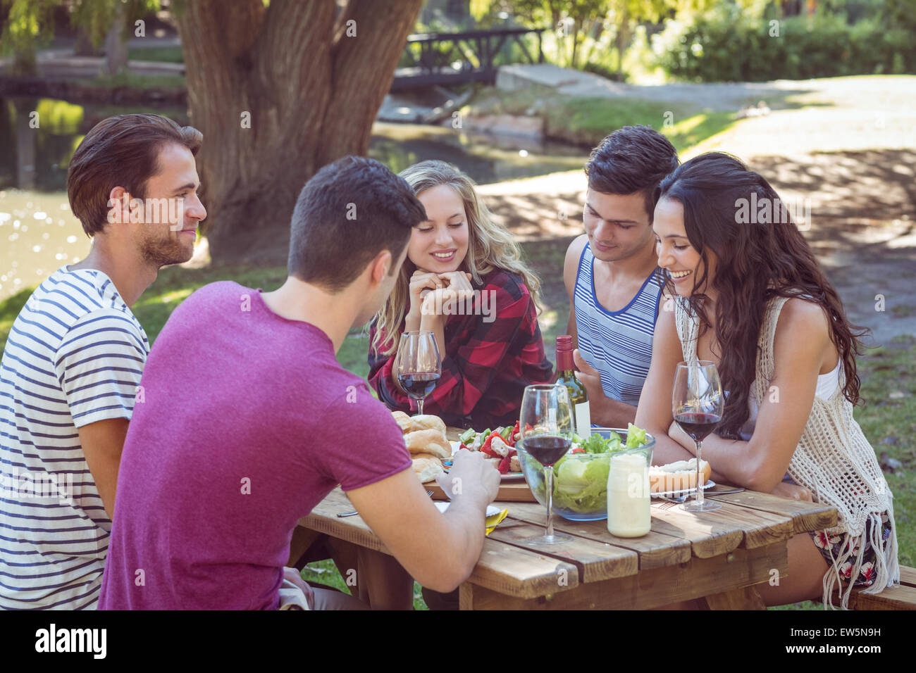 Happy friends in the park having beers Stock Photo - Alamy