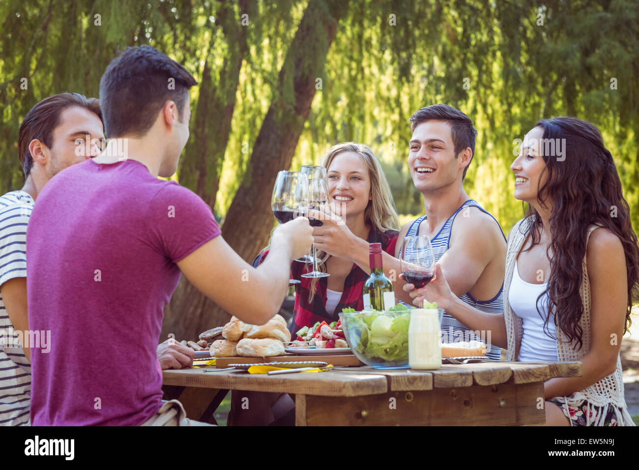 Happy friends in the park having beers Stock Photo - Alamy