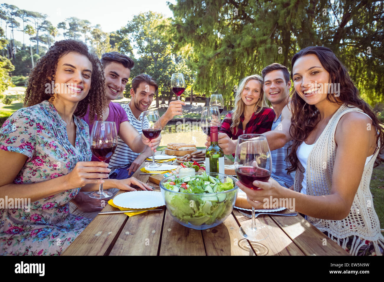 Happy friends in the park having lunch Stock Photo - Alamy