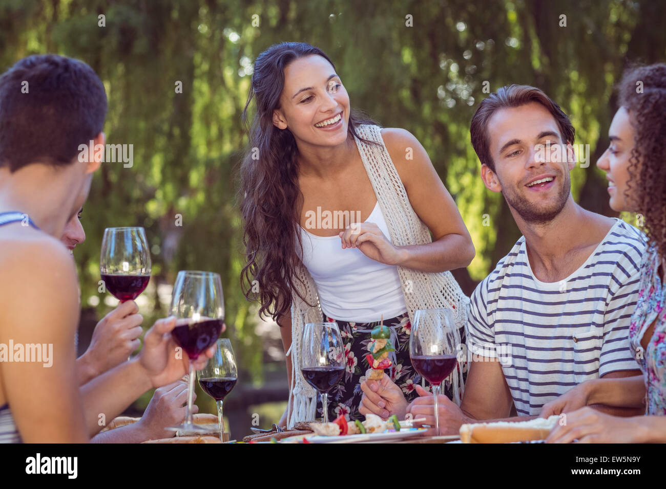 Happy friends in the park having lunch Stock Photo - Alamy