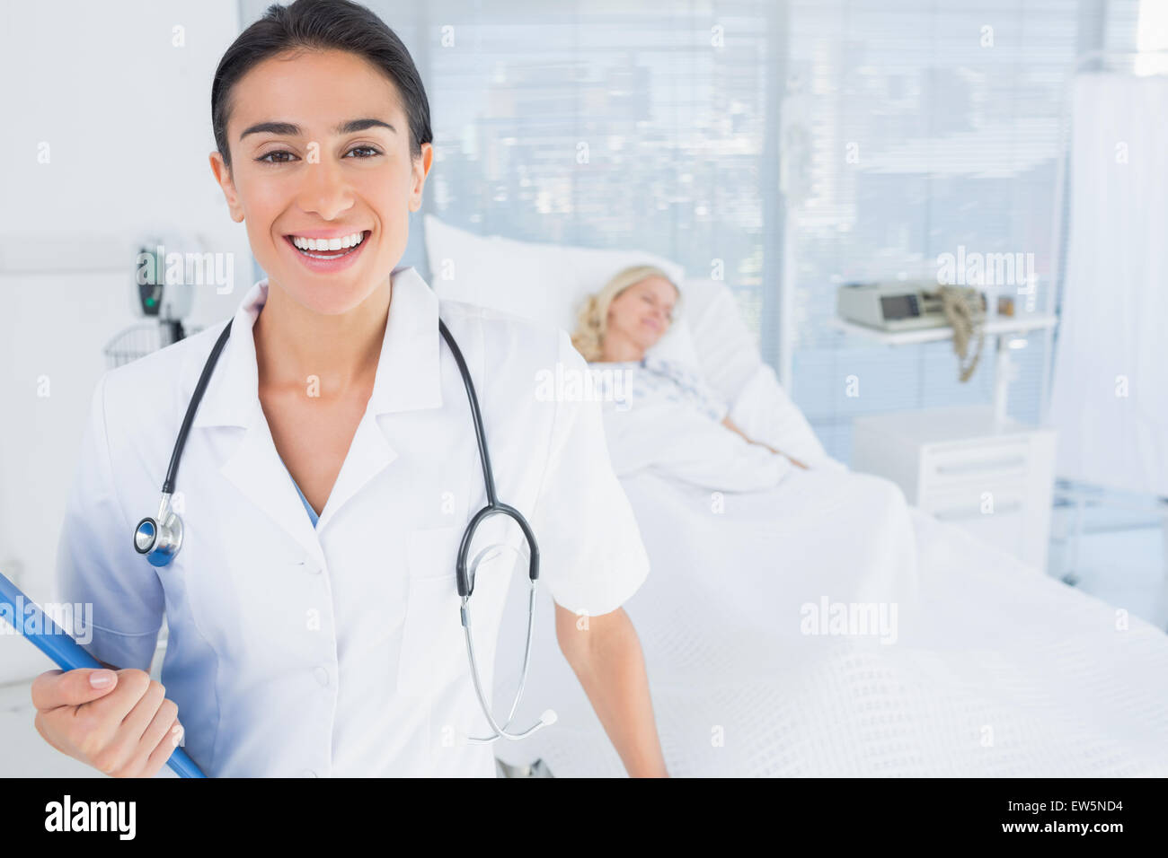 Smiling doctor looking at camera in patients room Stock Photo - Alamy