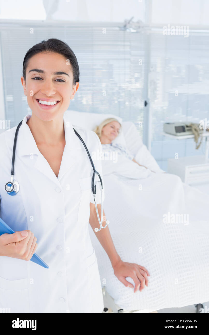 Smiling doctor looking at camera in patients room Stock Photo - Alamy