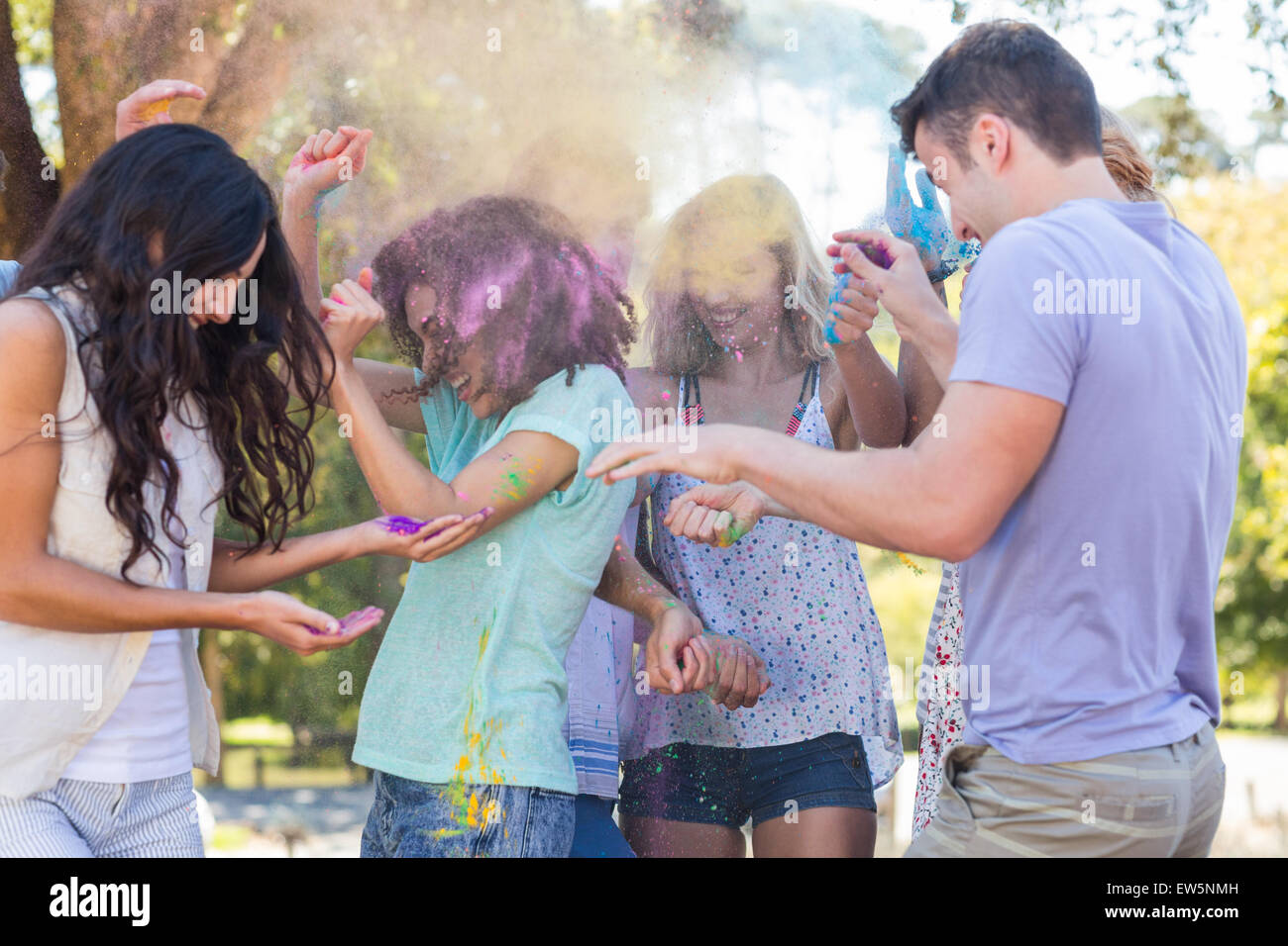 Friends throwing powder paint Stock Photo - Alamy