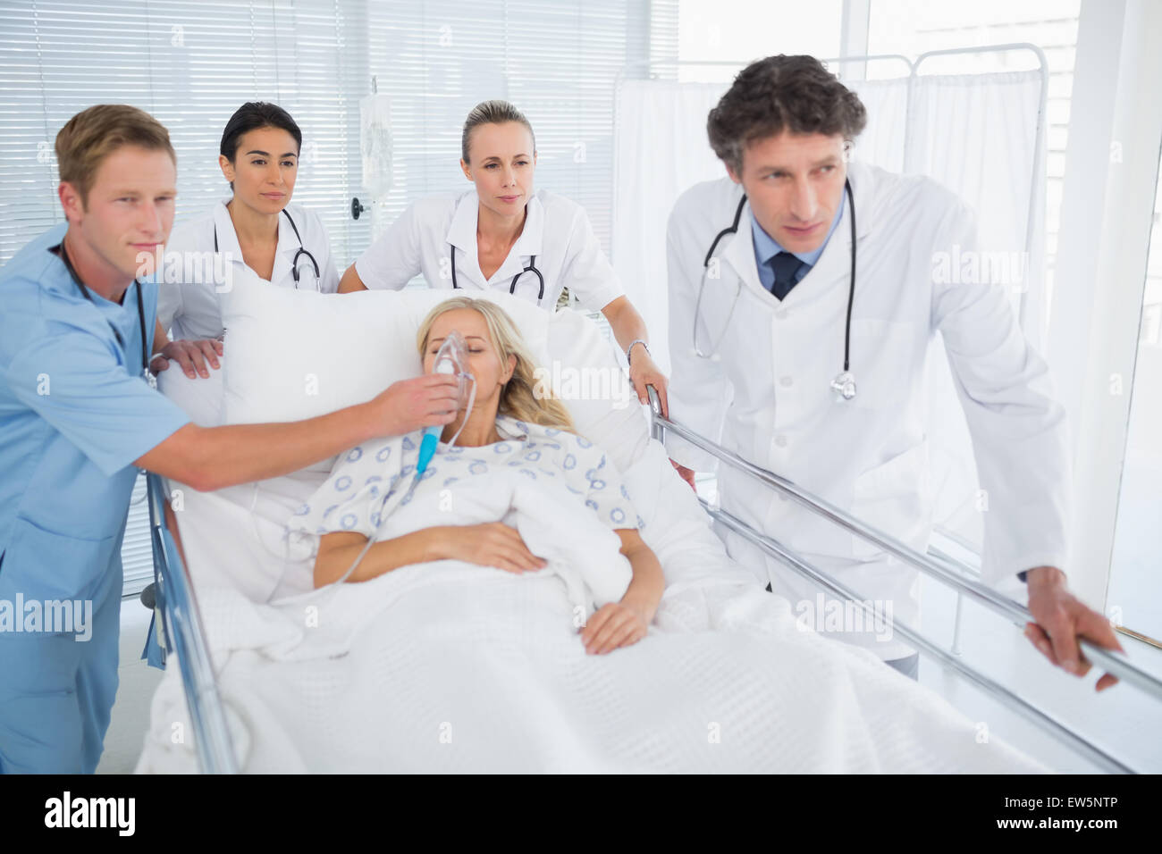 Team of doctors carrying patient on stretcher Stock Photo - Alamy