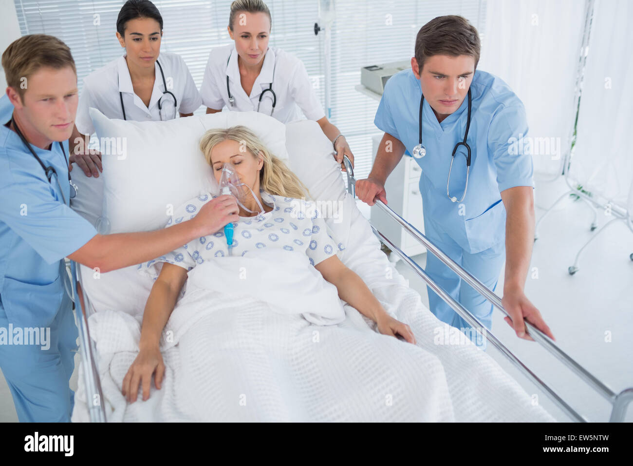 Team of doctors carrying patient on stretcher Stock Photo - Alamy
