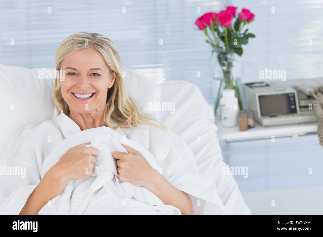 Smiling patient looking at camera on her bed Stock Photo - Alamy