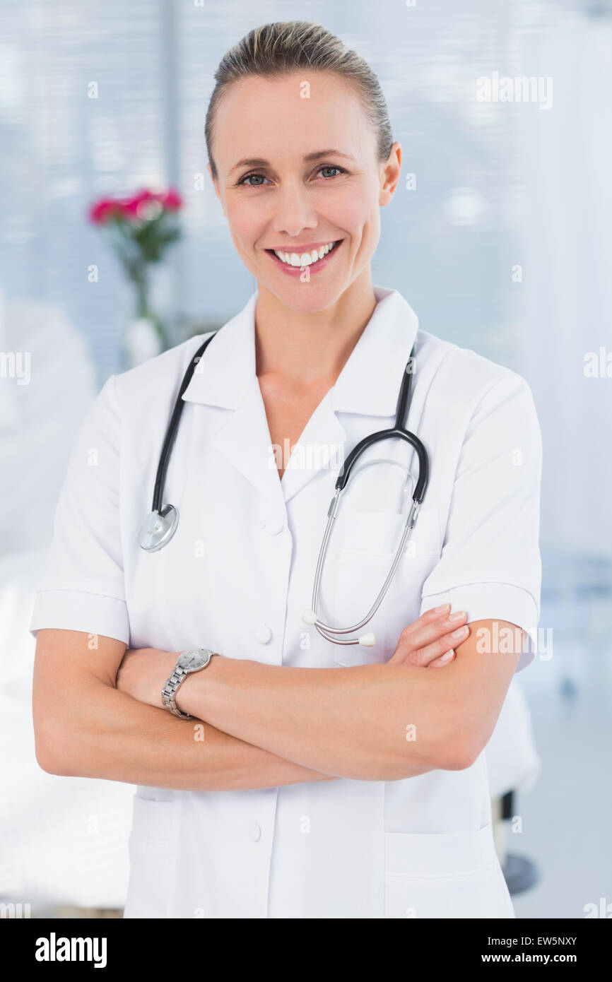 Happy doctor smiling at camera behind bed Stock Photo - Alamy