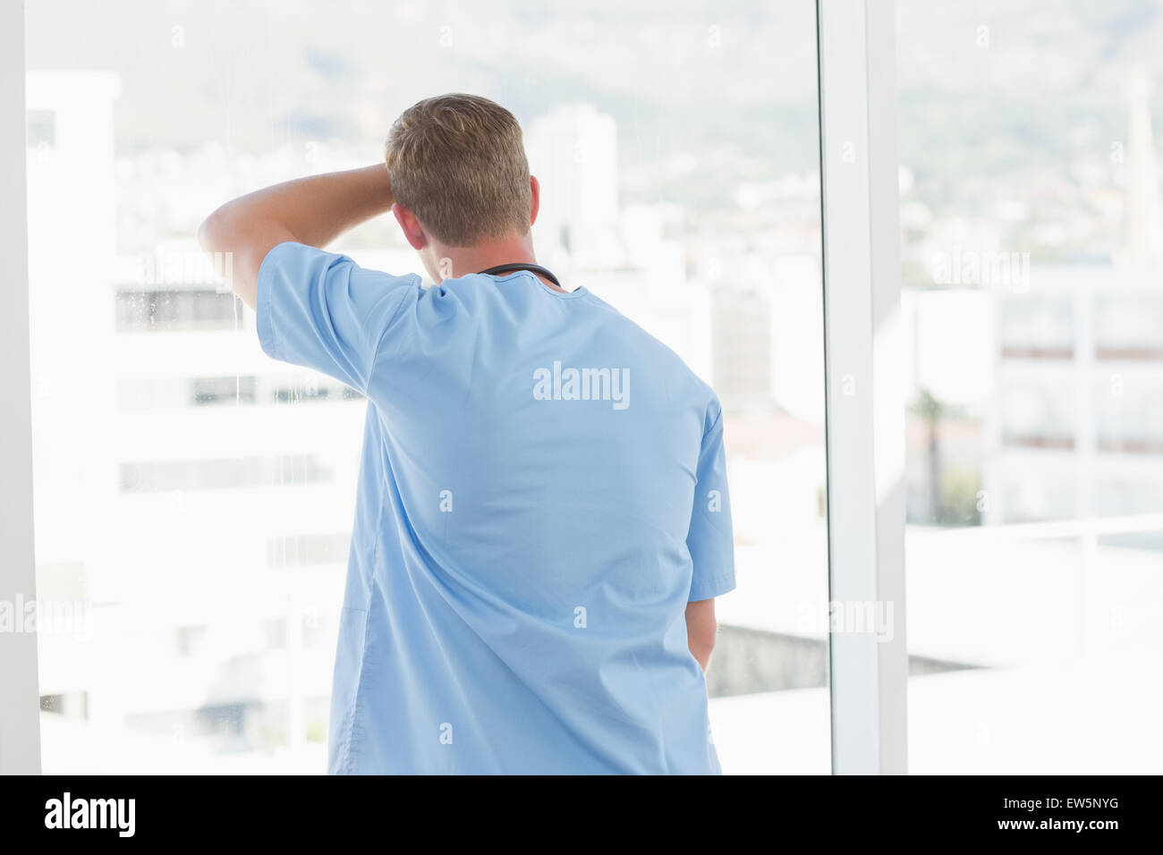 Male doctor looking through windows Stock Photo - Alamy