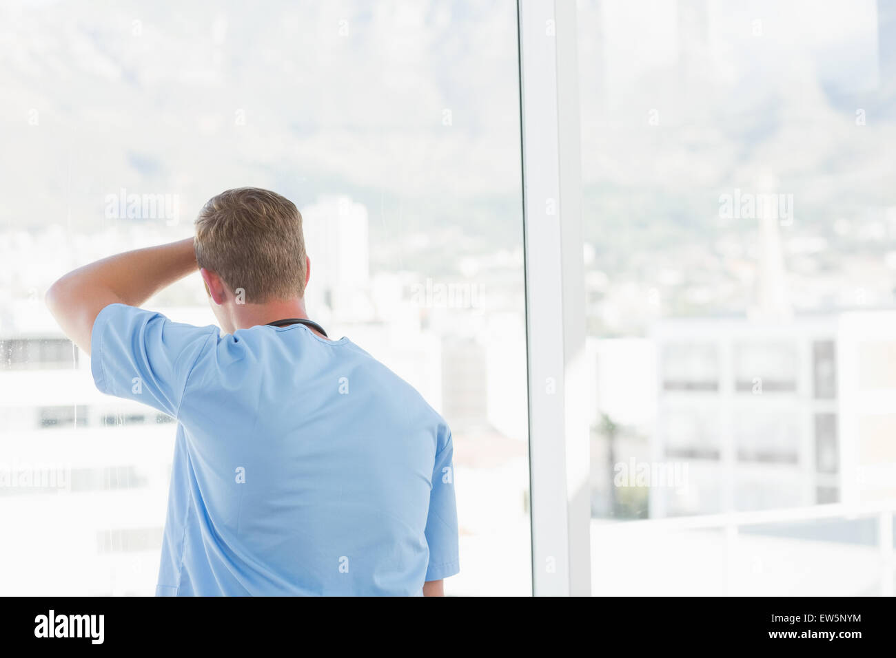 Male doctor looking through windows Stock Photo - Alamy