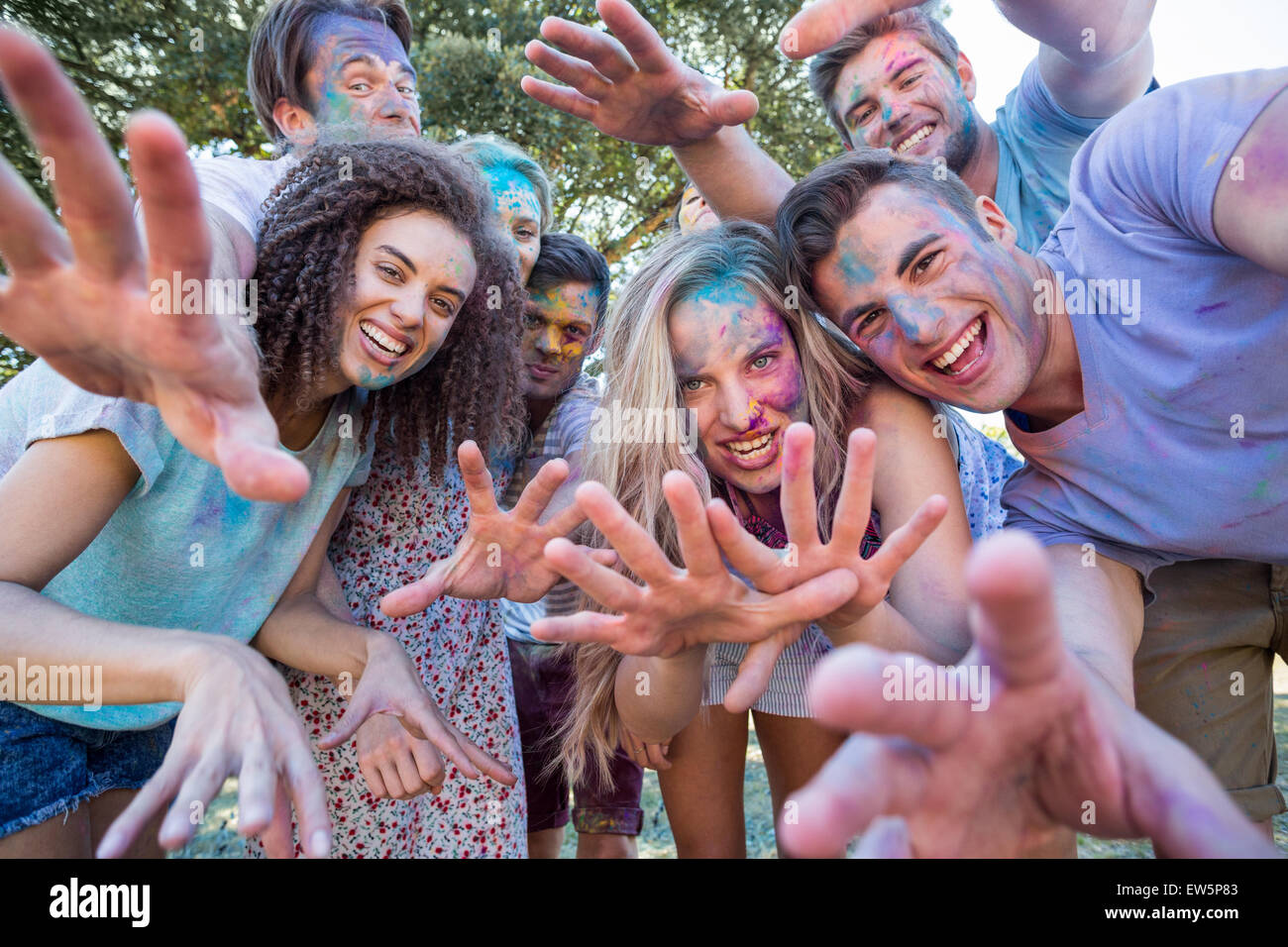 Happy friends covered in powder paint Stock Photo - Alamy