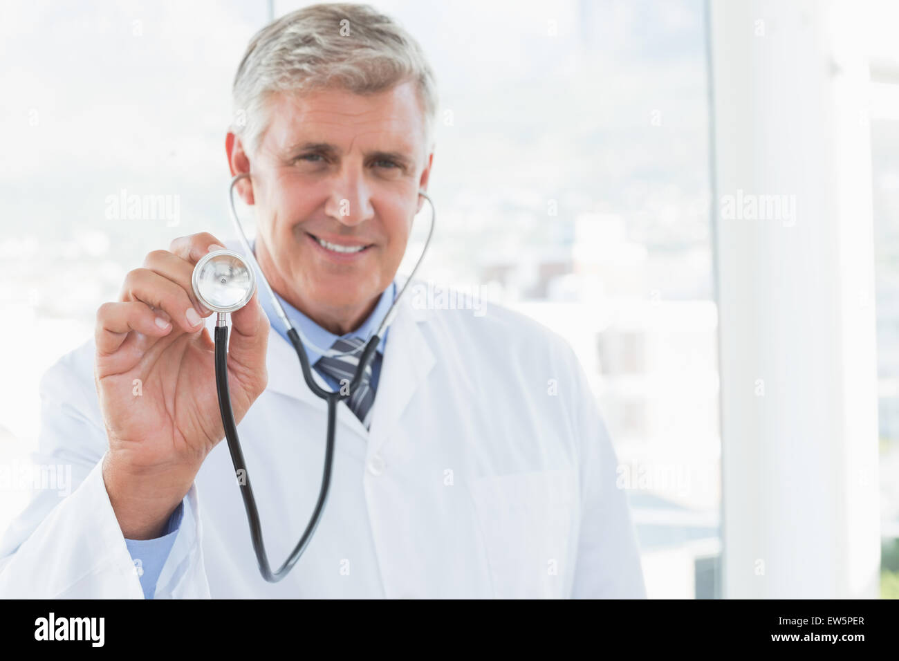 Happy doctor smiling at camera and showing his stethoscope Stock Photo ...