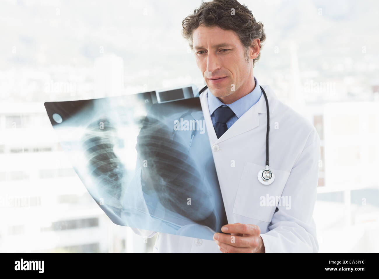 Serious doctor looking at X-ray Stock Photo - Alamy