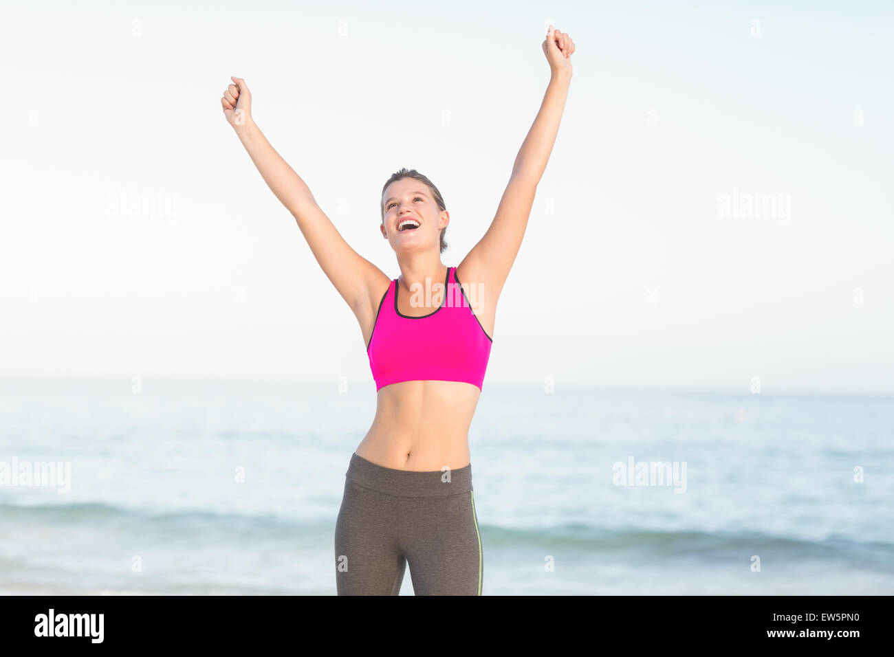 Wear view of beautiful fit woman cheering with arms rise Stock Photo ...