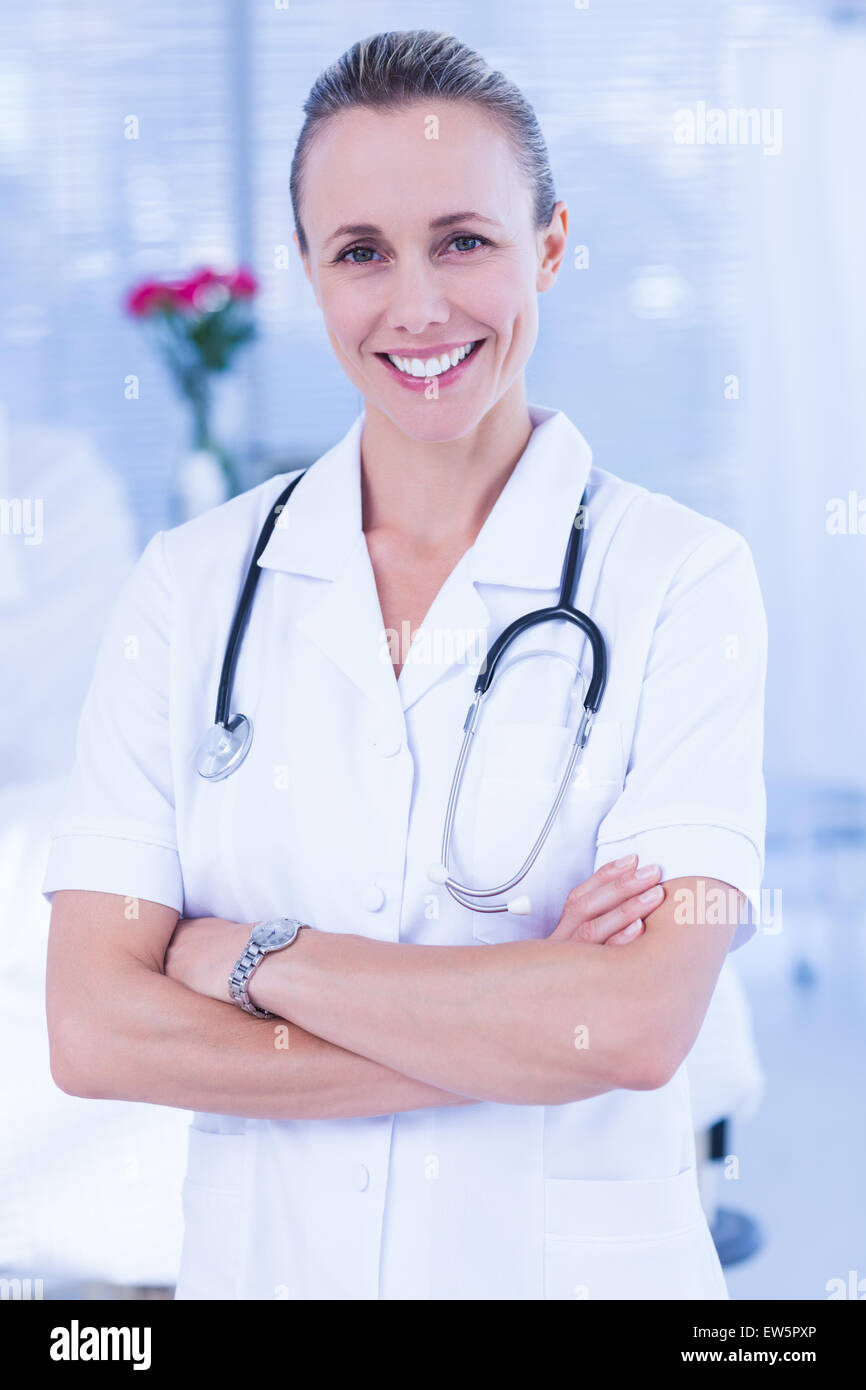 Happy doctor smiling at camera behind bed Stock Photo - Alamy
