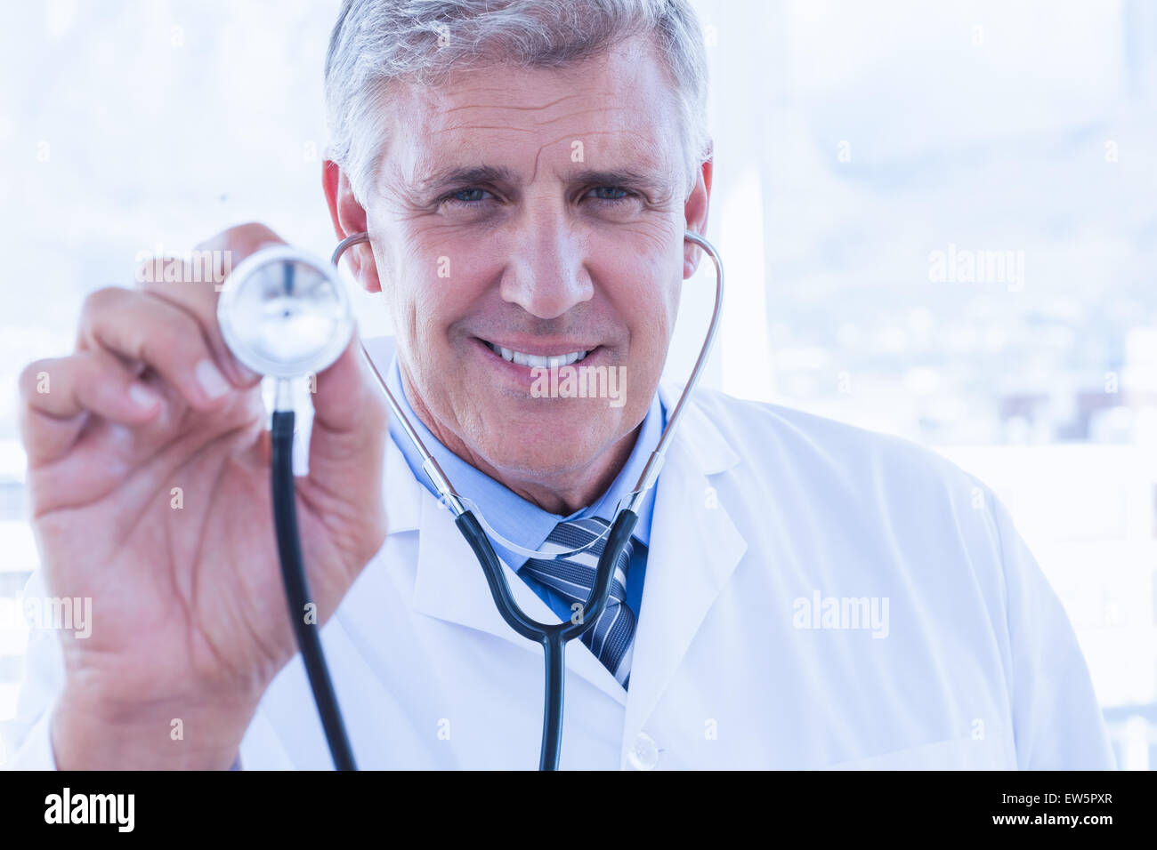 Happy doctor smiling at camera and showing his stethoscope Stock Photo ...