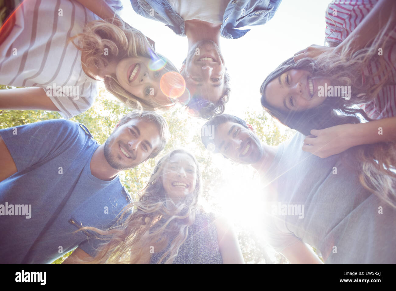 Happy friends huddling in circle in the park Stock Photo - Alamy